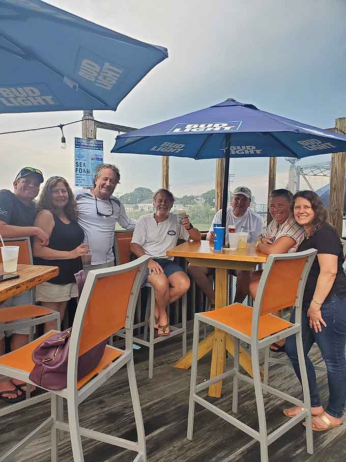 Friends gathered under umbrellas by the water capture exactly what summer dining should look like in Connecticut.