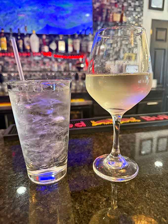 Crisp white wine and sparkling water at the bar, because sometimes the simplest choices are the most sophisticated ones.