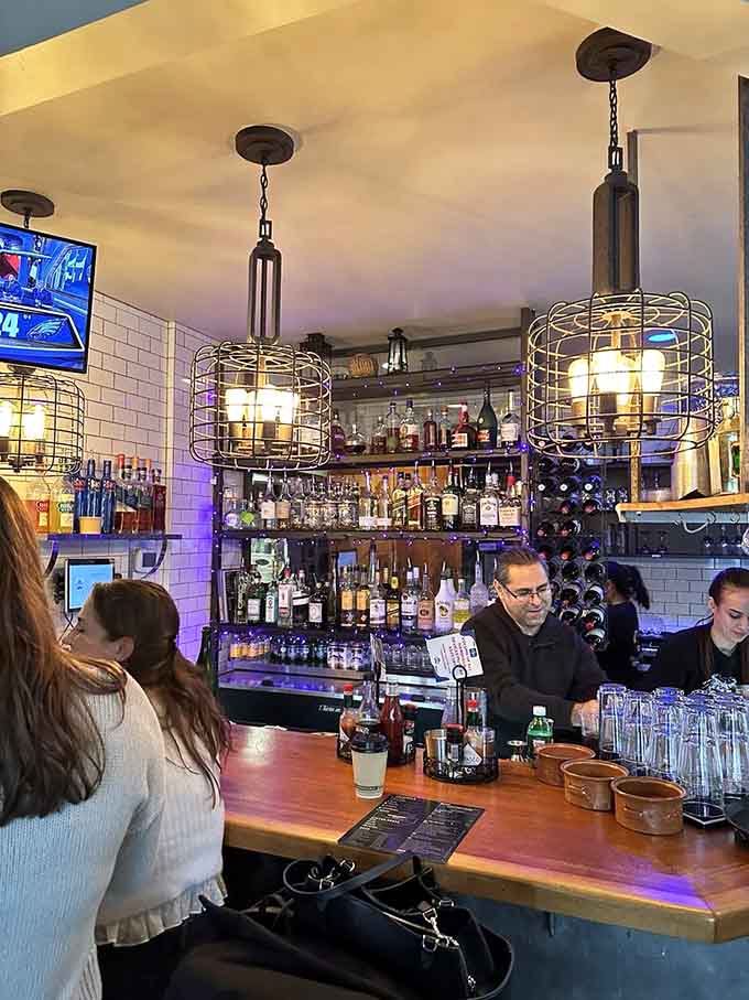 The bar area features cage-style pendant lights and a well-stocked selection. This is where the crew gathers for libations.