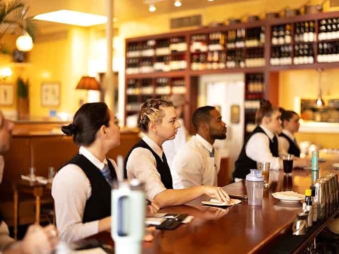 Professional servers in classic bistro attire ready to guide you through the best meal you'll have all week.