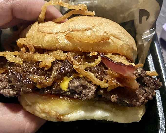 The Tombstone Burger lives up to its name with layers that require architectural planning and serious jaw commitment.