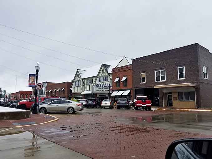 Rain-slicked streets reflect the Royal Theater and neighboring shops, creating an atmospheric scene worthy of a vintage movie still.