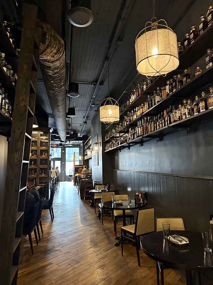 The long dining room with vintage signage and a fireplace proves that barbecue joints can have architectural sophistication and soul.