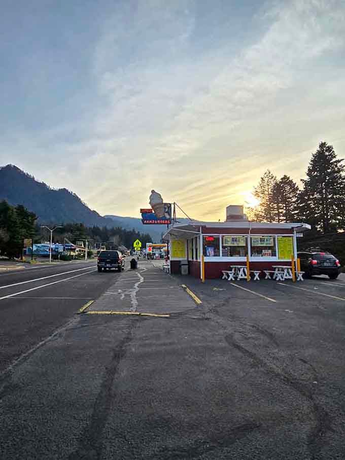 Sunset behind the mountains, iconic sign glowing, this is where road trip memories are made forever.