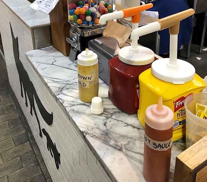 Condiment station loaded with squeeze bottles of possibility, where customization meets personal responsibility and delicious choices happen.