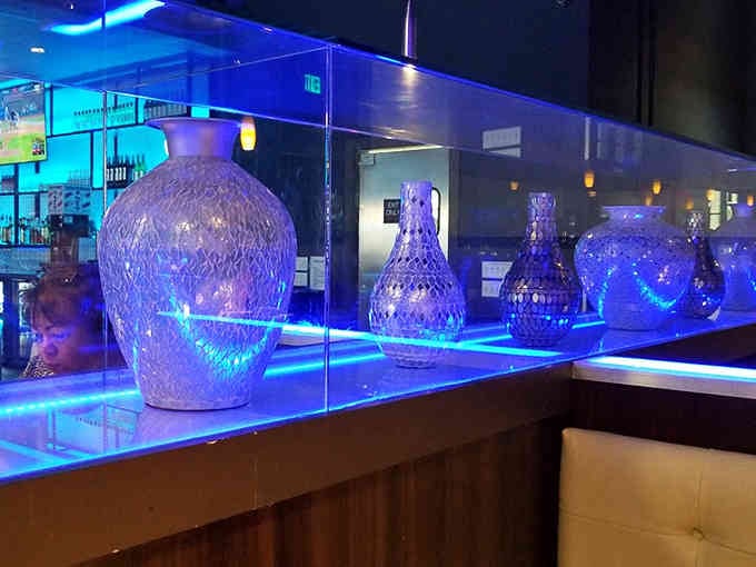 Decorative vases catch the blue light beautifully, adding artistic flair to a restaurant that takes its meat very seriously.