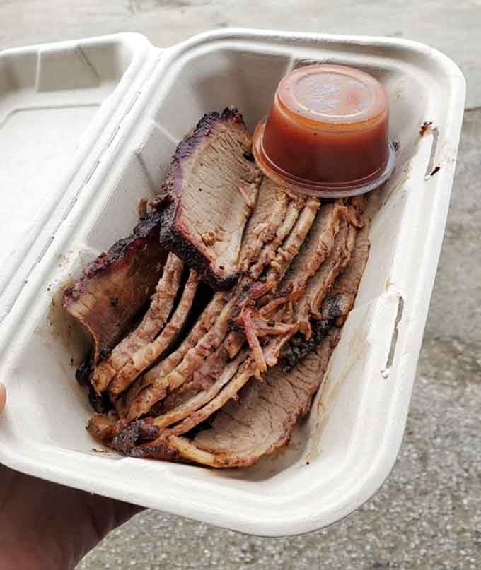 Sliced brisket revealing that perfect pink smoke ring, the universal sign that someone really knows their craft.