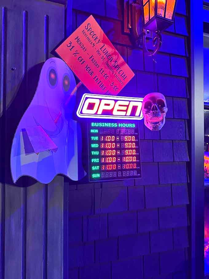 Business hours posted on the door with ghostly decorations, because even spirits need to know when dinner is served.