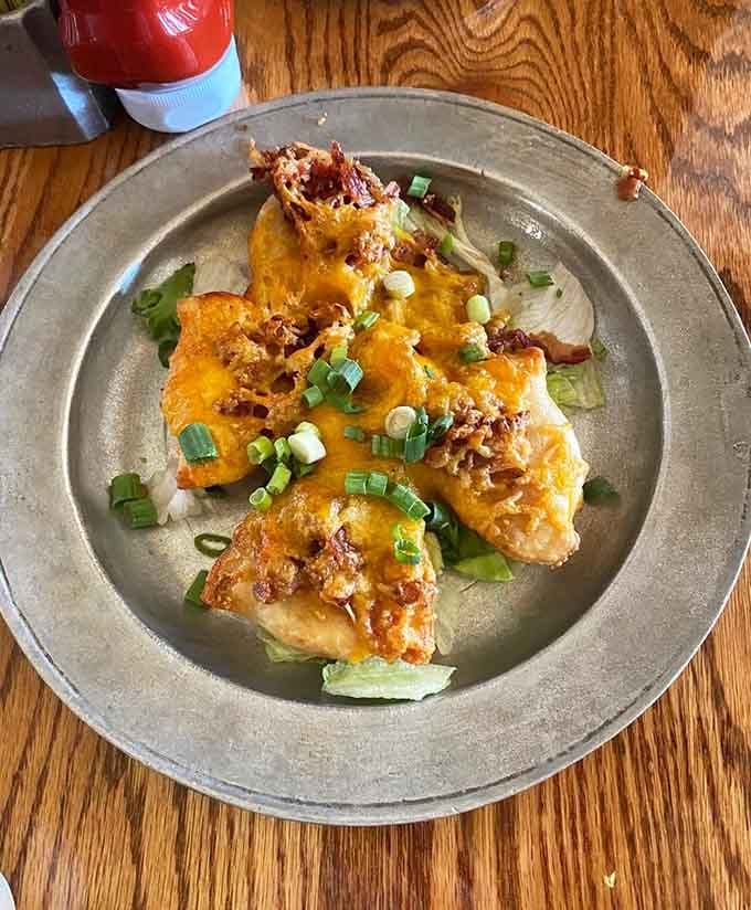 Fried pierogis topped with cheese and bacon, because Pennsylvania knows exactly what comfort food should taste like always.
