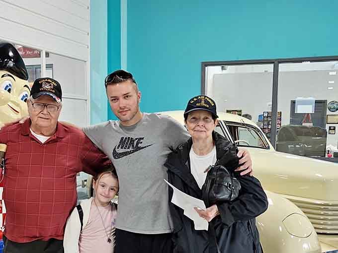 Happy diners pose with vintage vehicles, proving that good food and cool trucks make everyone smile regardless of age.