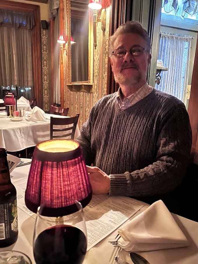 A satisfied diner enjoys the ambiance where Victorian elegance meets Midwestern hospitality in perfect harmony every night.