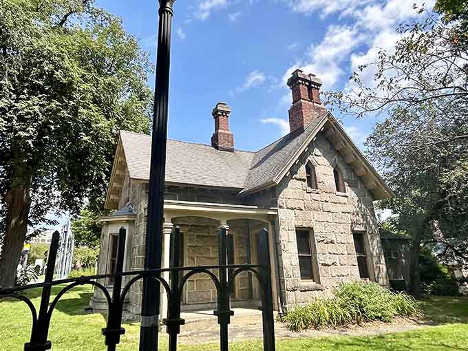 The stone gatehouse stands guard over manicured grounds, reminding visitors that even the staff quarters had better architecture than most mansions.
