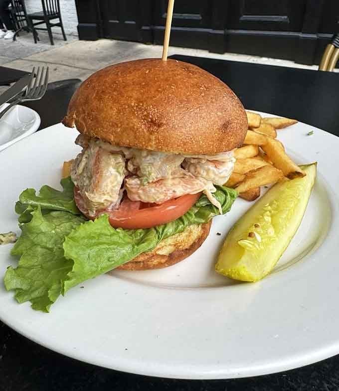 That shrimp salad sandwich overflowing its bun is what happens when generosity meets deliciousness on toasted bread.