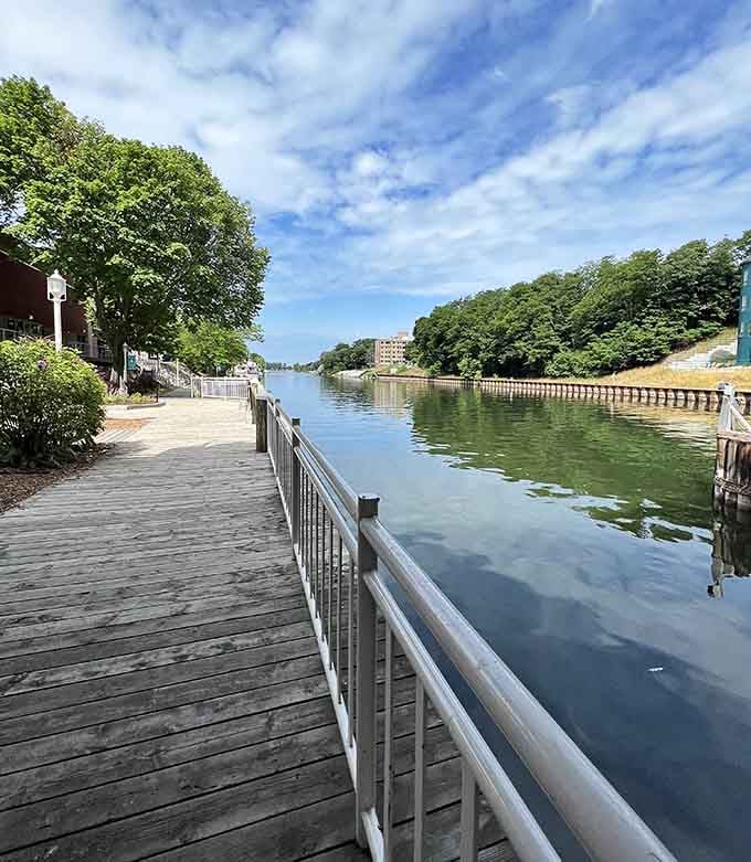 The pathway hugs the water so closely you can almost reach out and touch the river's glassy surface.