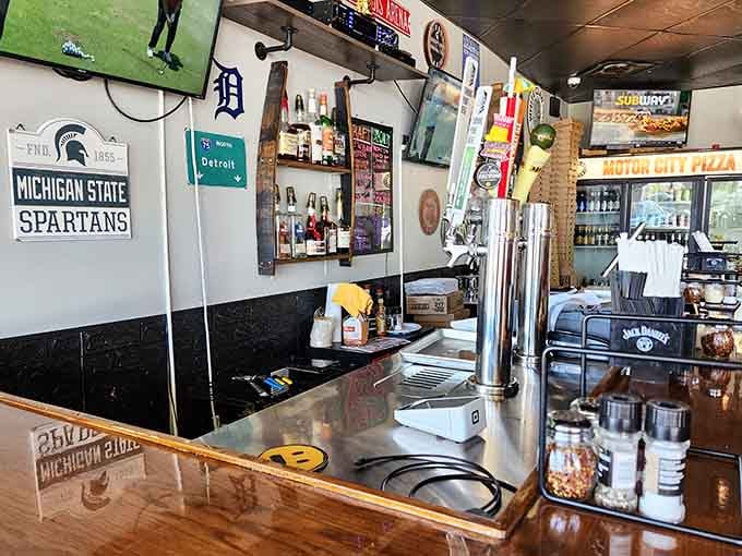 The bar area showcasing Michigan pride with Spartans gear, because good pizza and college loyalty go together.