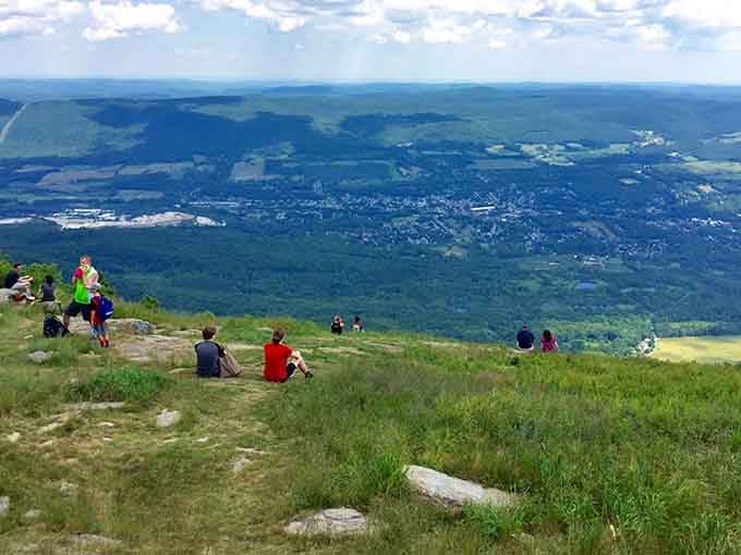 Summit visitors sprawl on the grass, soaking in panoramic views that stretch across five states.