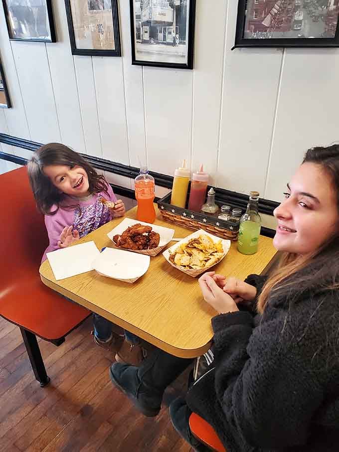 Multi-generational dining at its finest, where kids and parents share the same enthusiasm for perfectly sauced hot dogs together.