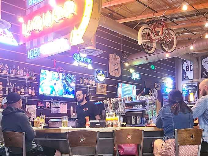 That vintage bicycle suspended overhead adds whimsy to a bar area where cold drinks meet warm hospitality.