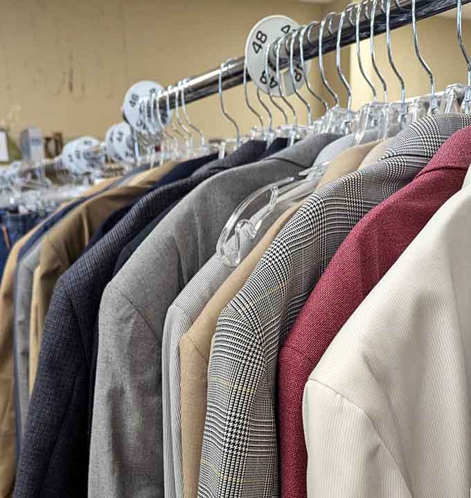 Business casual blazers hang in neat rows, ready to outfit your next job interview or office presentation.