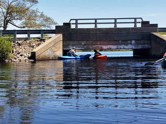 Kayakers gliding under bridges discover peaceful waterways that feel miles away from the everyday hustle and stress.