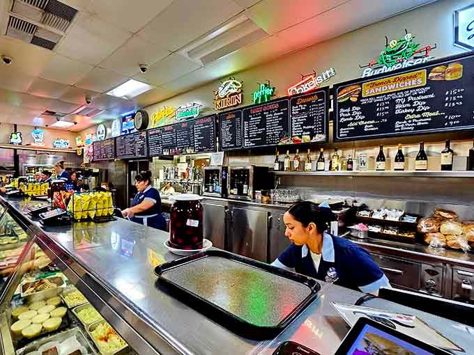 The efficient staff behind the counter slicing meat and assembling sandwiches like a well-choreographed culinary ballet performance.