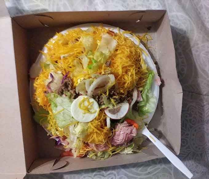 A salad topped with chili and cheese, because vegetables taste better when they're mostly a suggestion beneath the good stuff.