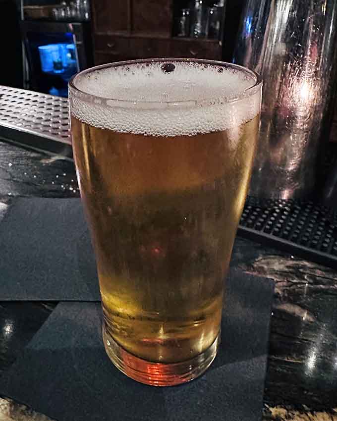 A cold beer waiting patiently to wash down hot pizza, the partnership that's worked since time began.