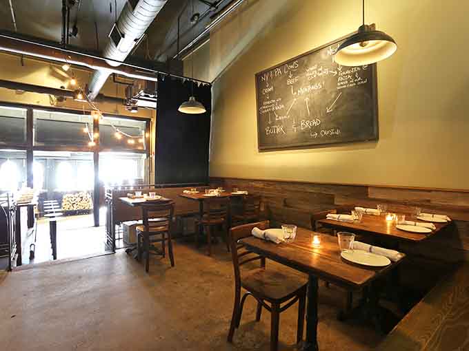 Cozy tables and that stunning distressed wall create an atmosphere where great food meets genuine comfort and conversation.