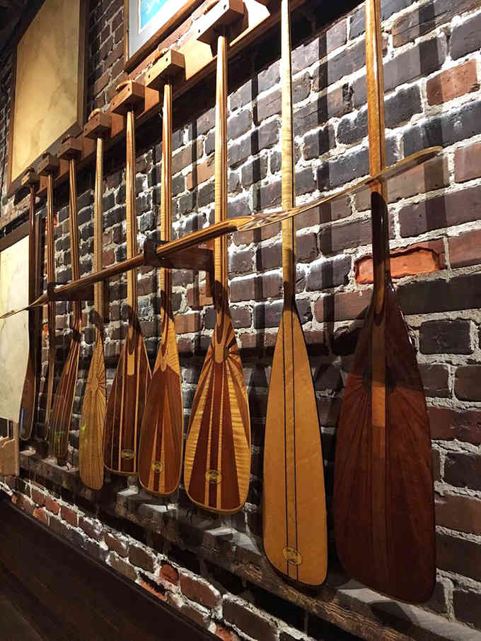 Wooden paddles line the brick wall like edible art museum pieces, adding authentic maritime charm to your dining experience.
