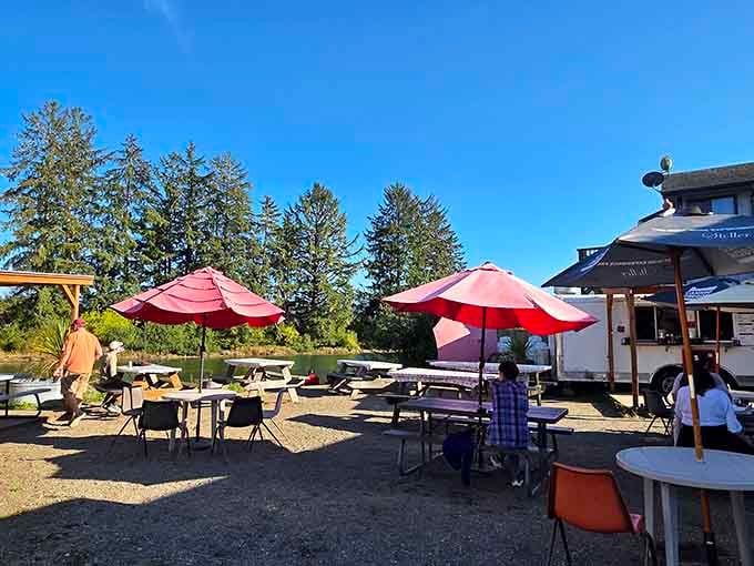 Red umbrellas and picnic tables under open sky make every meal feel like a special summer occasion.