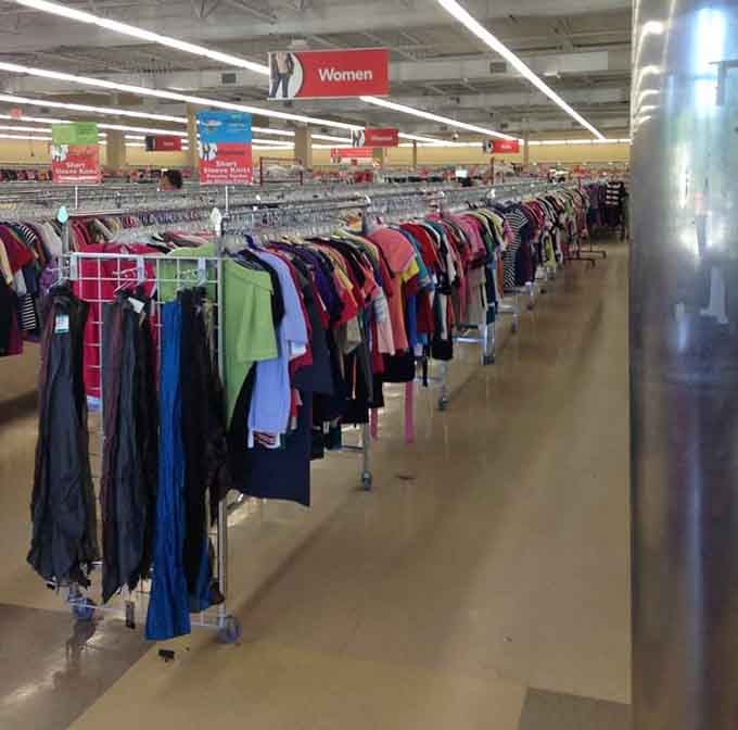 Women's clothing racks stretching endlessly, organized by color like a thrifter's version of shopping paradise realized.