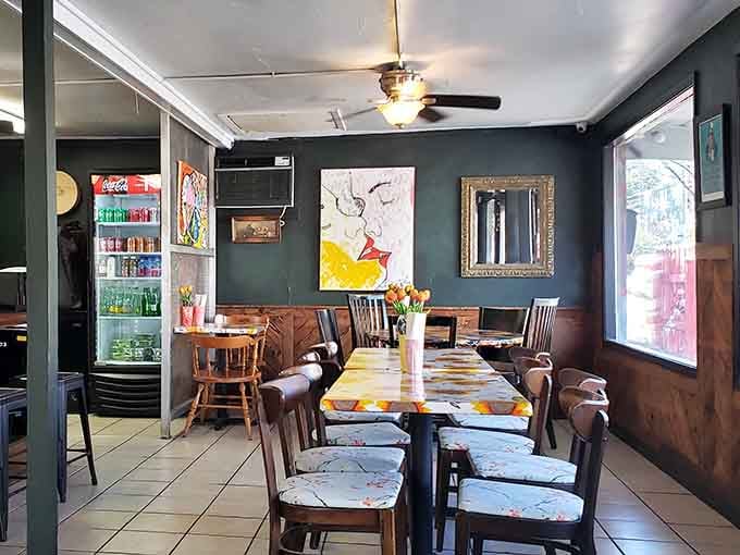 Eclectic artwork adorns dark walls while those painted tables steal the show, making every meal feel like a celebration.