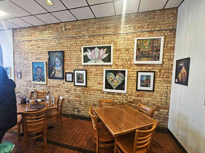 Exposed brick and rotating local artwork transform simple walls into a gallery you can actually enjoy while eating.