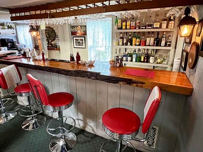 A classic bar with red stools and polished wood proves that some design choices never go out of style.