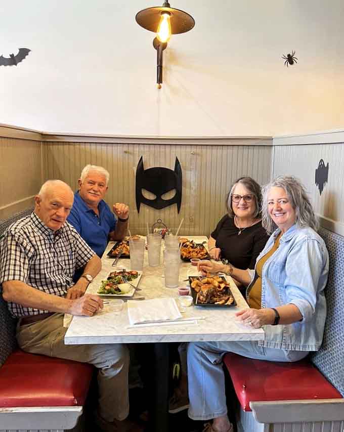 Happy diners under a Batman mask prove that superhero-themed restaurants work for all ages and appetites.