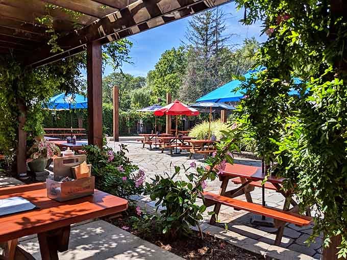 The outdoor patio offers shaded seating surrounded by greenery, perfect for enjoying barbecue in the fresh air.