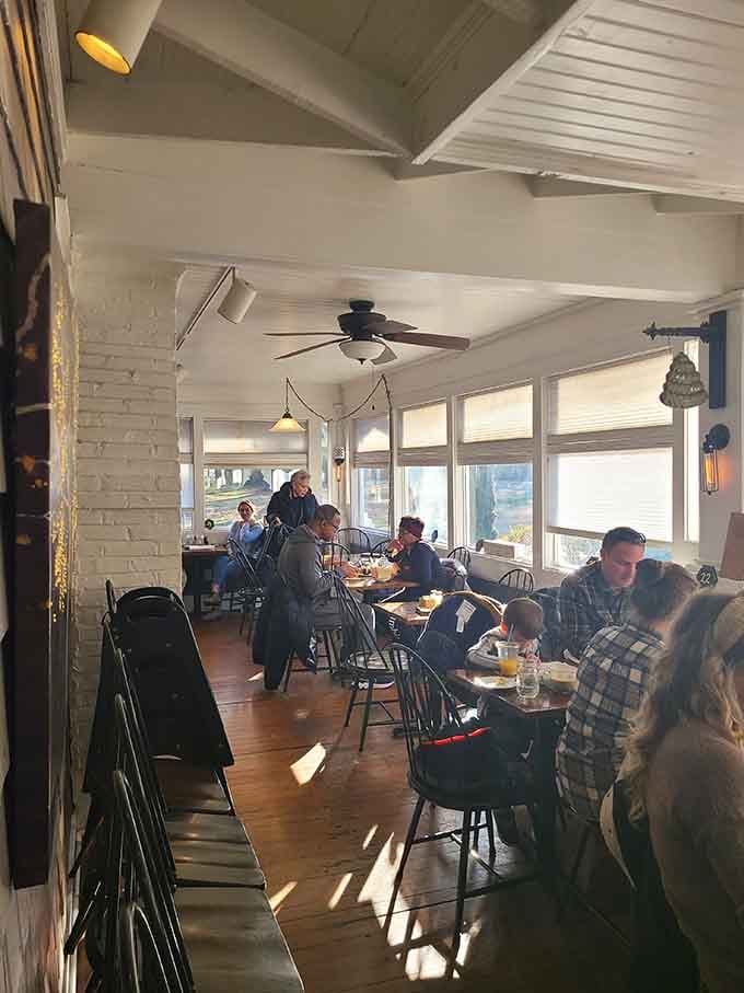 Sunlit dining room filled with happy people who've clearly discovered where breakfast dreams actually come true daily.