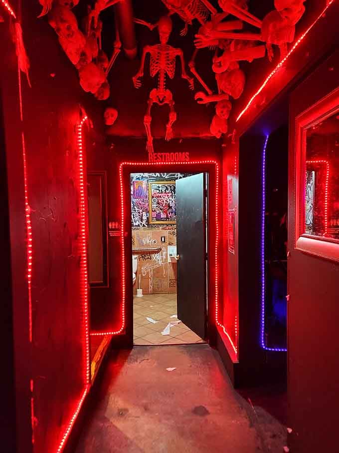 Even the restroom entrance gets theatrical treatment with red lights and skeletons, because why stop the theme anywhere?