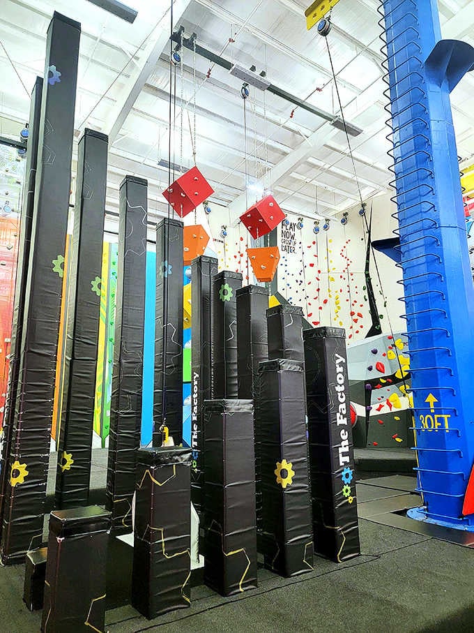 Black jumping pillars dangle from above like a geometric obstacle course designed by someone who really understood childhood joy.