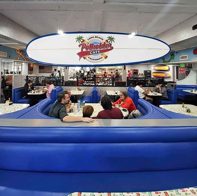 That surfboard sign overhead watches diners tackle portions that require actual strategy and possibly a nap afterward.