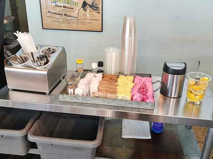 The condiment station stands ready with colorful sweetener packets, because even coffee deserves options and a little personality boost.