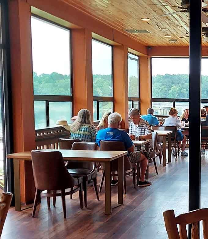 Diners enjoying lakeside meals with views that make you wonder why anyone eats anywhere without water and windows.