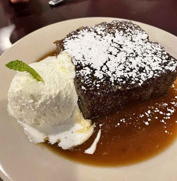 Sticky toffee pudding dusted with powdered sugar like fresh snow on a delicious, date-filled mountain.