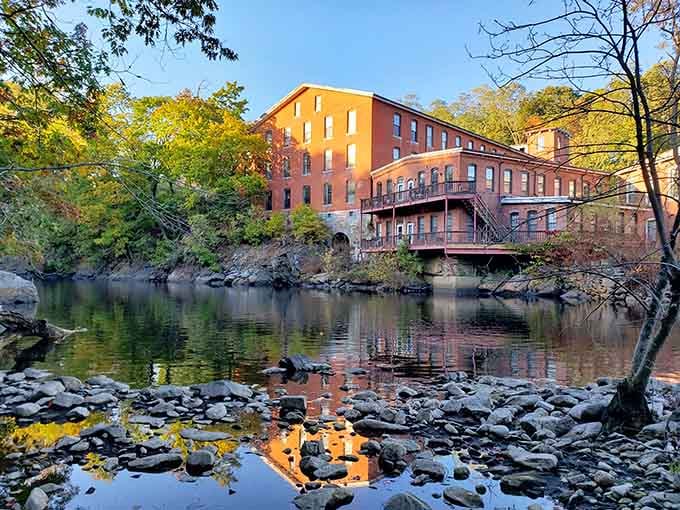 The historic mill building stands as a reminder of when this waterpower drove industry, now peacefully restored.