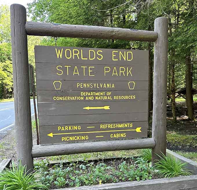The classic wooden park sign points you toward parking, cabins, and memories you'll be talking about for years.