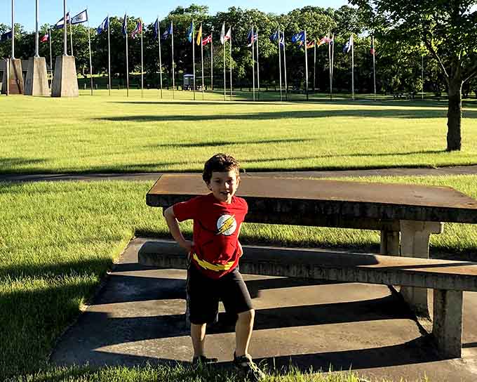Concrete picnic tables invite visitors to linger and contemplate life under the watchful eye of their corvid companion.
