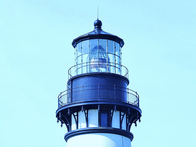 The lantern room's intricate glasswork catches light like a giant crystal chandelier designed by very practical French engineers with excellent taste.