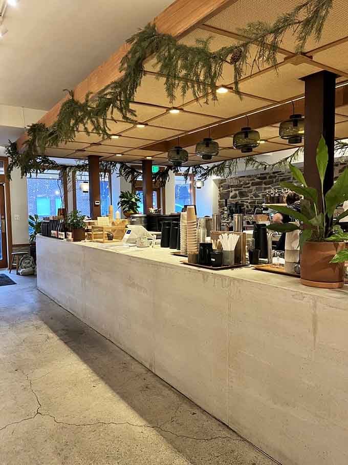 That concrete counter draped in greenery creates an urban jungle vibe that makes ordering coffee feel like a mini vacation.