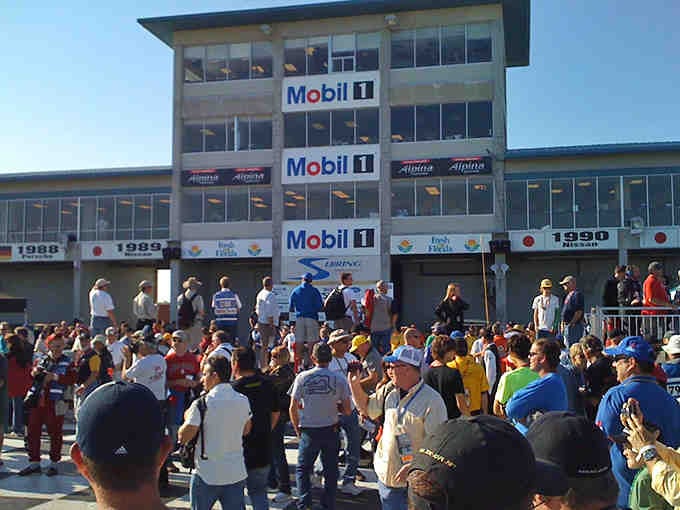 Race fans pack the grandstands like sardines, but the happy kind who chose to be there together.