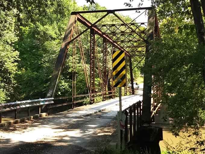 That warning sign stands sentinel, its stripes faded but message clear: proceed with caution and maybe a good luck charm.